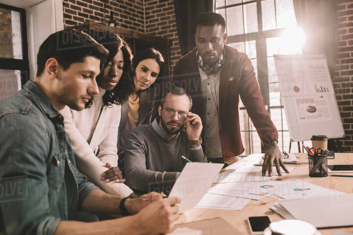 Serious multiethnic group of colleagues working together on new project ...