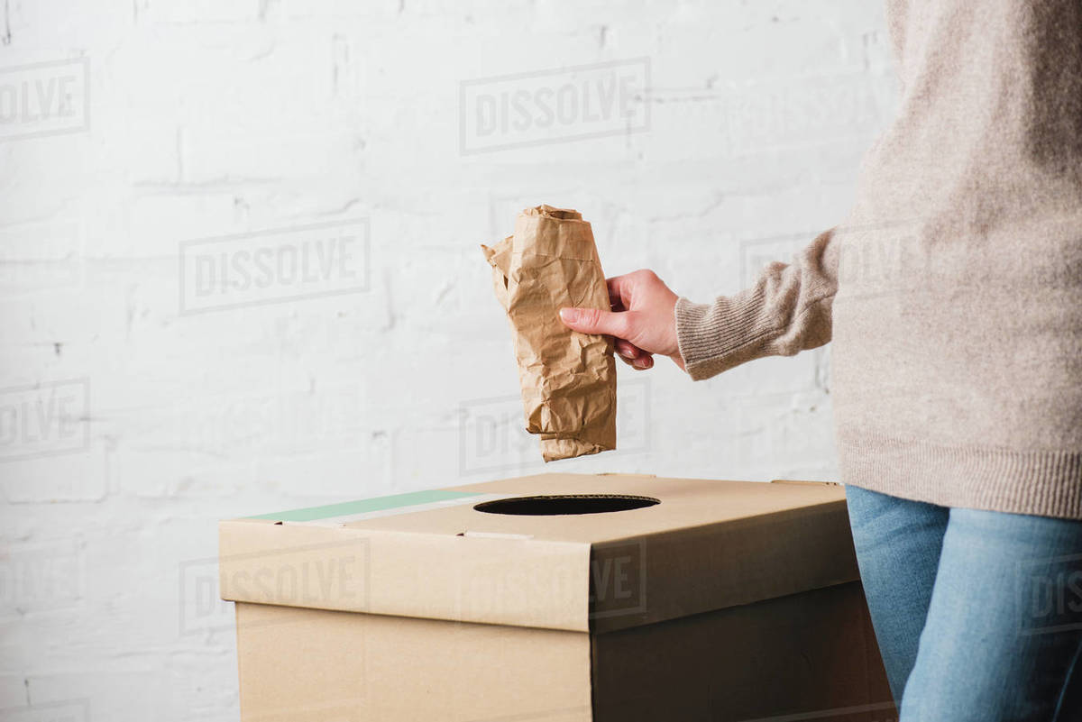 Partial view of woman throwing paper in trash bin - Royalty-free Stock ...