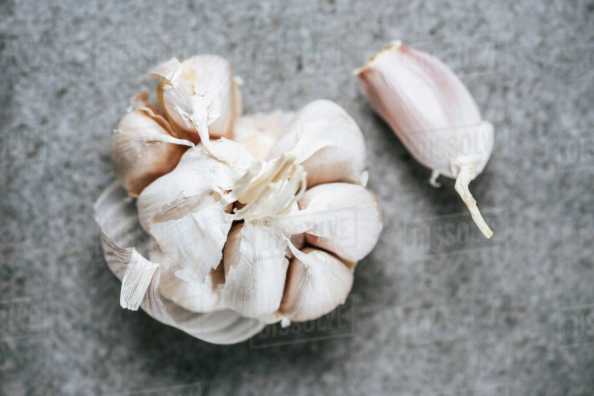 Top view of peeled ripe garlic bulb on grey background - Royalty-free ...