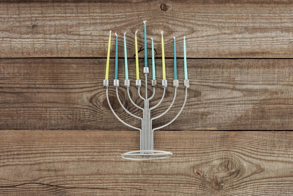 Top view of traditional Jewish menorah with blue and yellow candles on ...