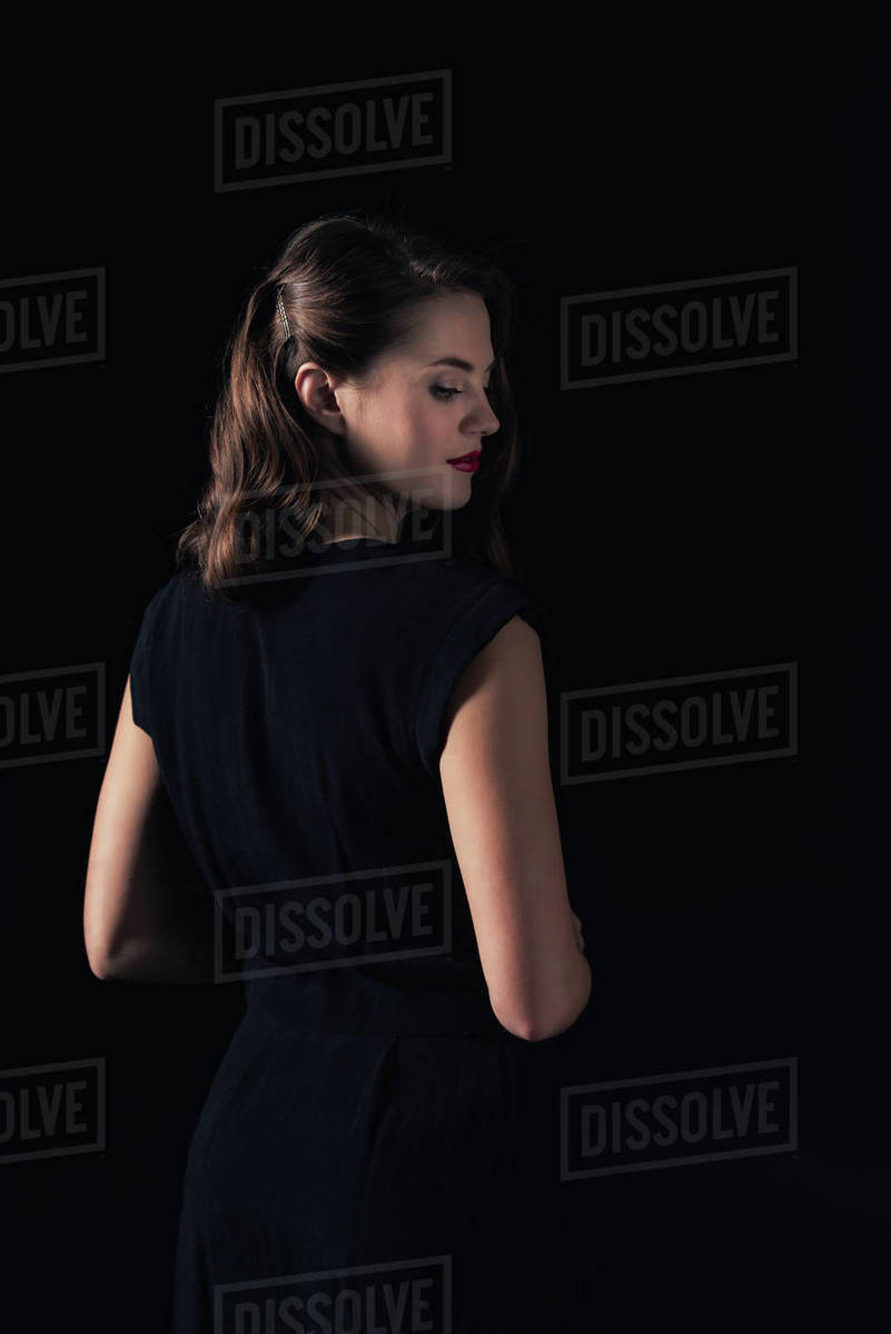Back view of beautiful woman in dress posing isolated on black ...