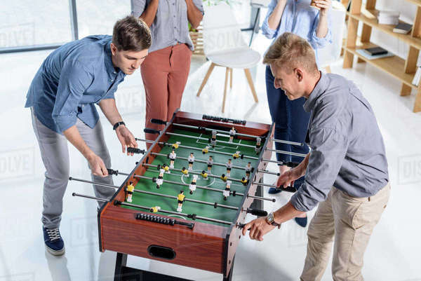 Business people playing table football in modern office - Stock Photo ...