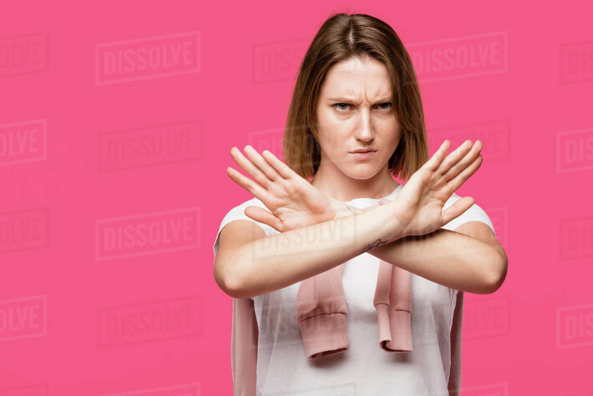 angry young woman showing stop gesture with crossed arms isolated on ...