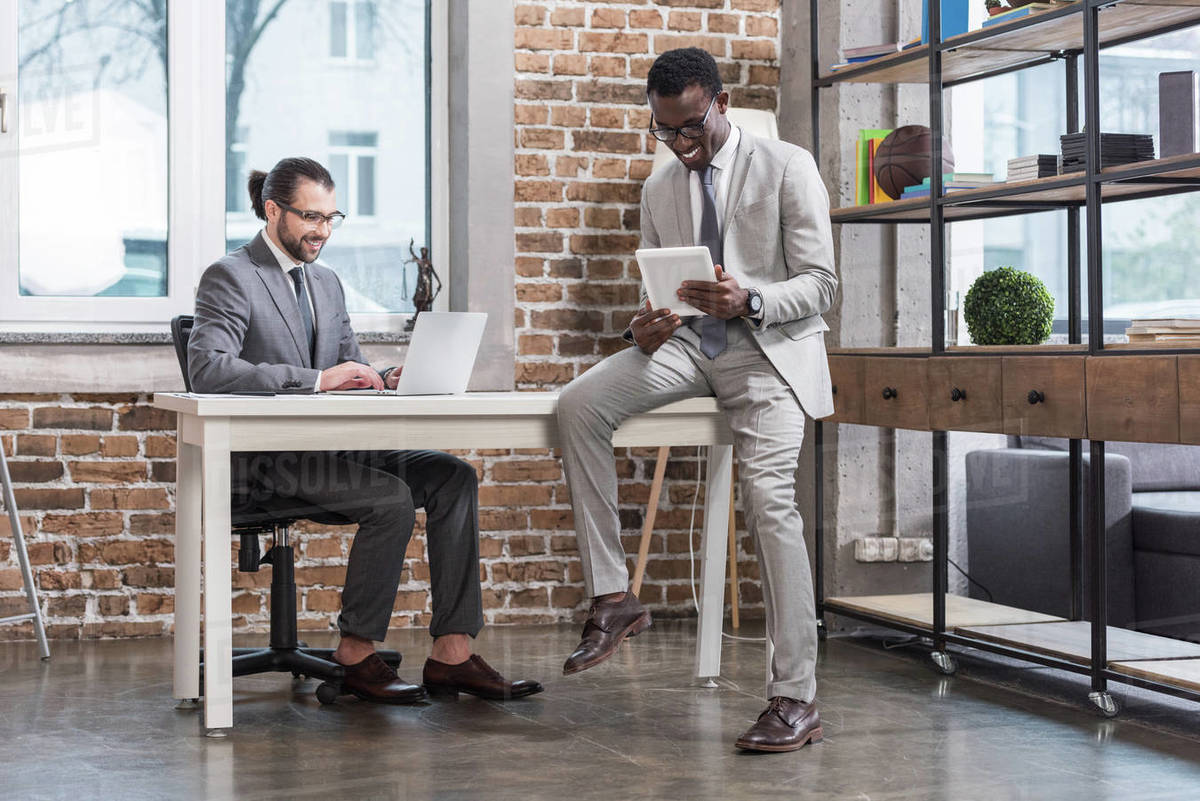 handsome man typing on laptop keyboard and african american business ...