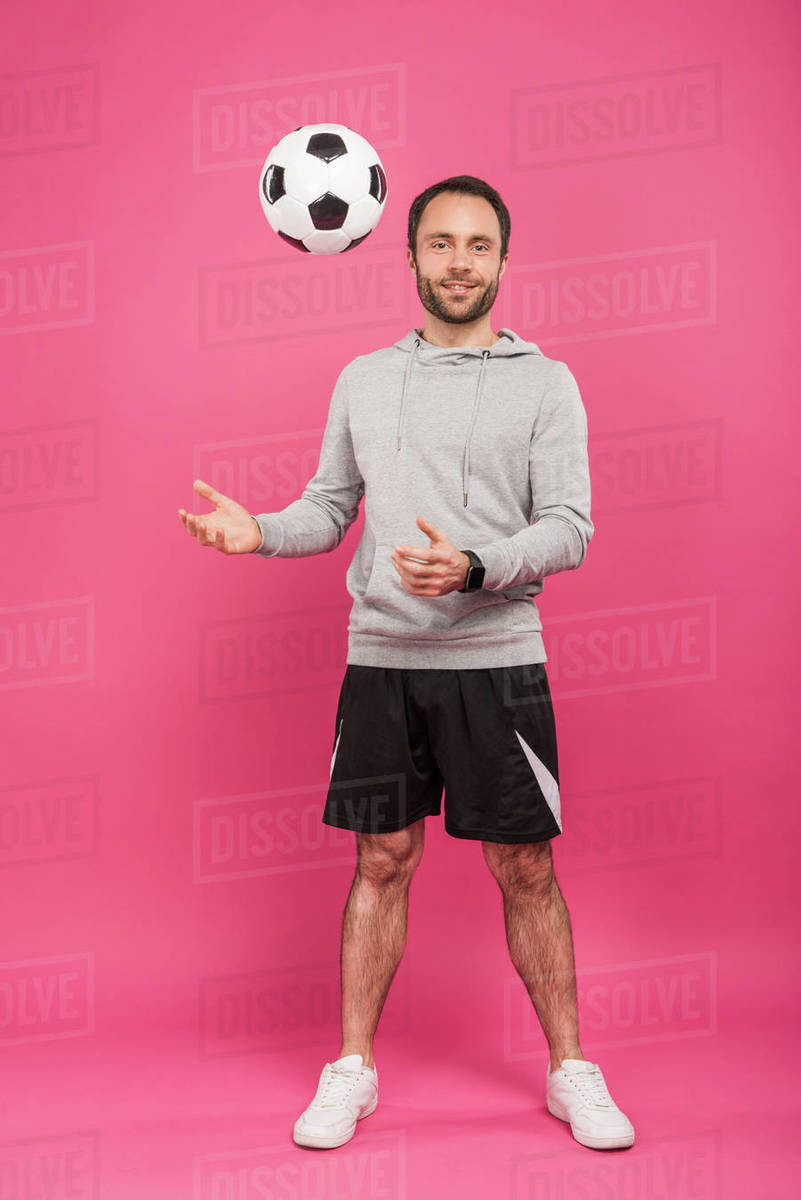 nale football player throwing up ball isolated on pink - Royalty-free ...