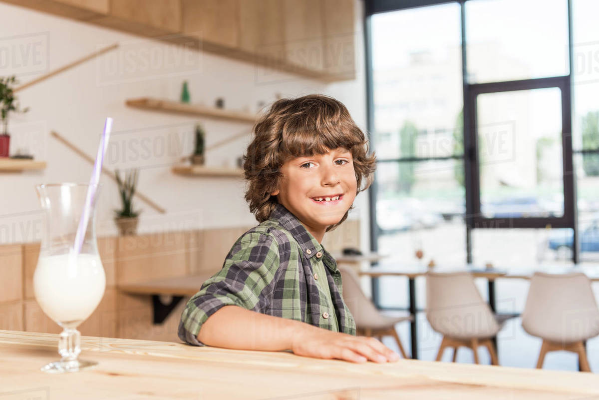 Cute little boy sitting in cafe with milkshake on bar counter - Royalty ...