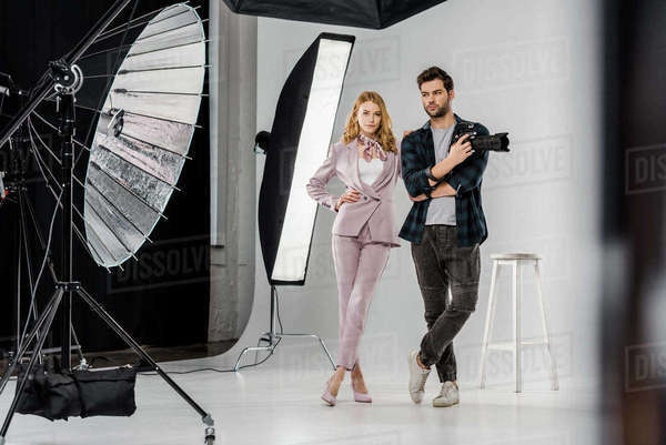 Young photographer camera and beautiful female model standing together ...