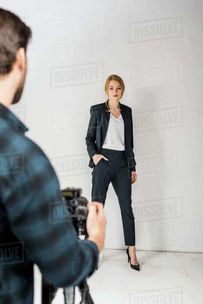 Cropped shot of young man photographing beautiful model in photo studio ...