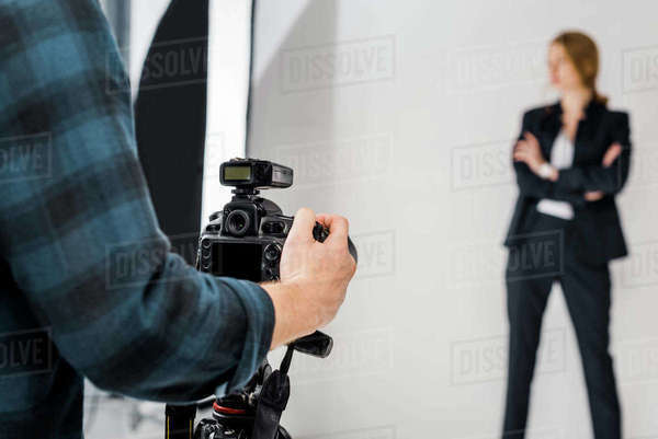 Cropped shot of photographer with camera shooting beautiful model in ...