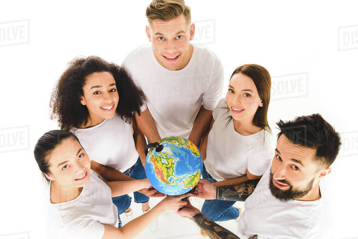 Overhead view of multicultural group holding globe and smiling while ...