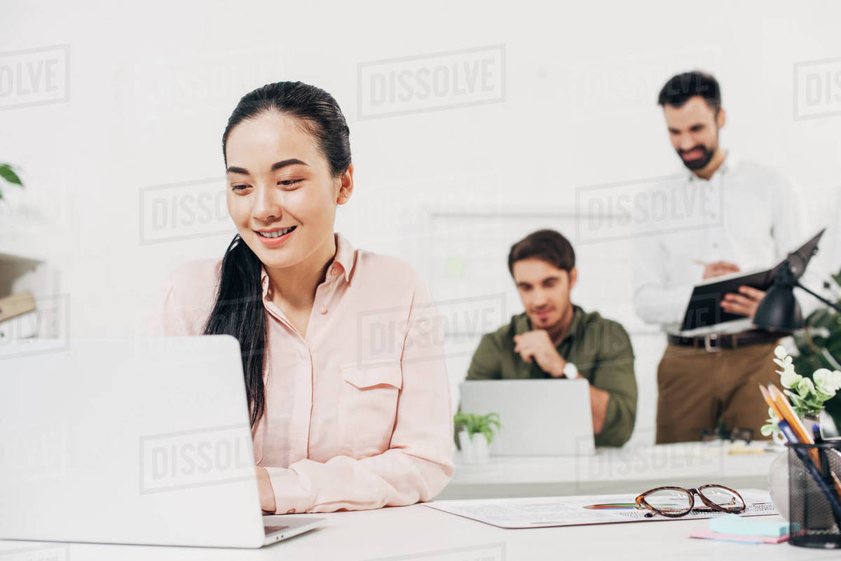 Selective focus of female manager looking at laptop in office - Royalty ...