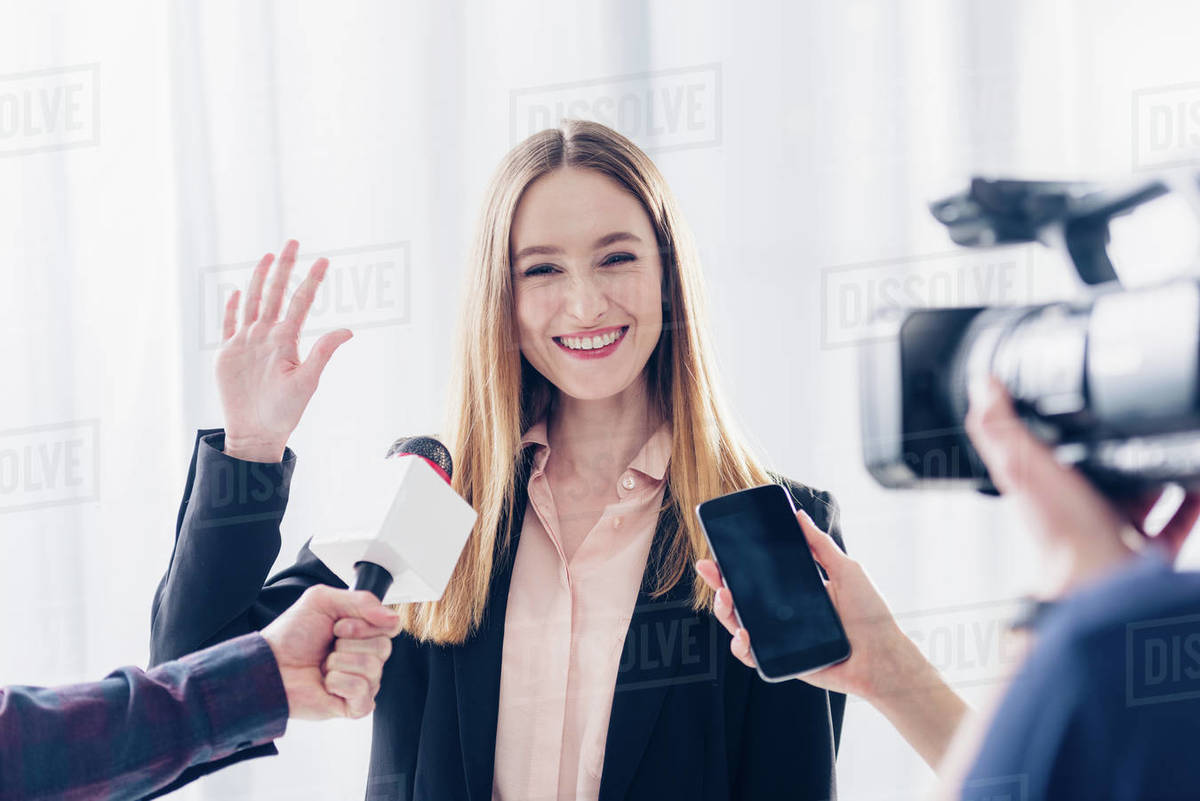 Happy attractive businesswoman giving interview to journalists and ...