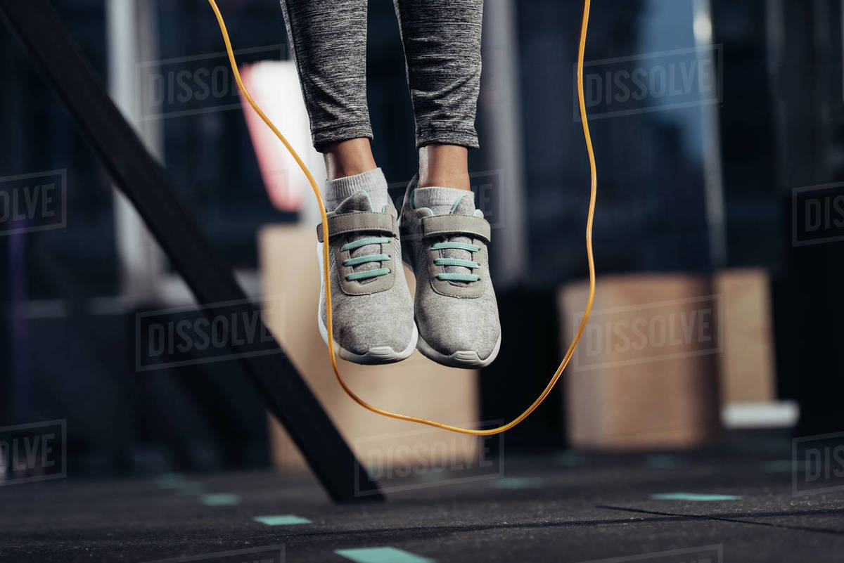 Cropped view of female legs jumping with skipping rope at gym - Royalty ...