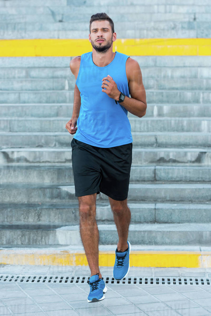 Athletic sportsman running on stairs in city - Stock Photo - Dissolve