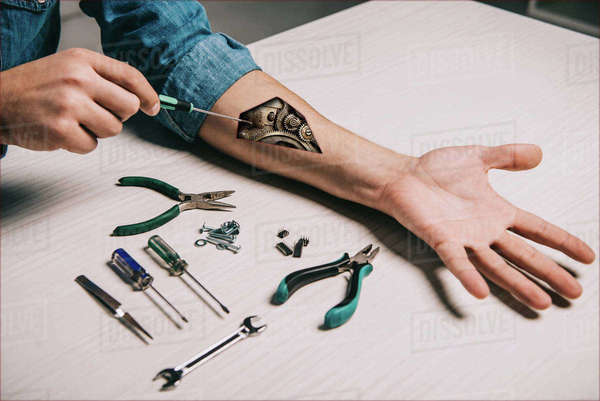 Cropped view of man repairing metallic mechanism in arm with wrench and ...