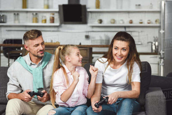 Happy family playing video game together in living room - Stock Photo ...