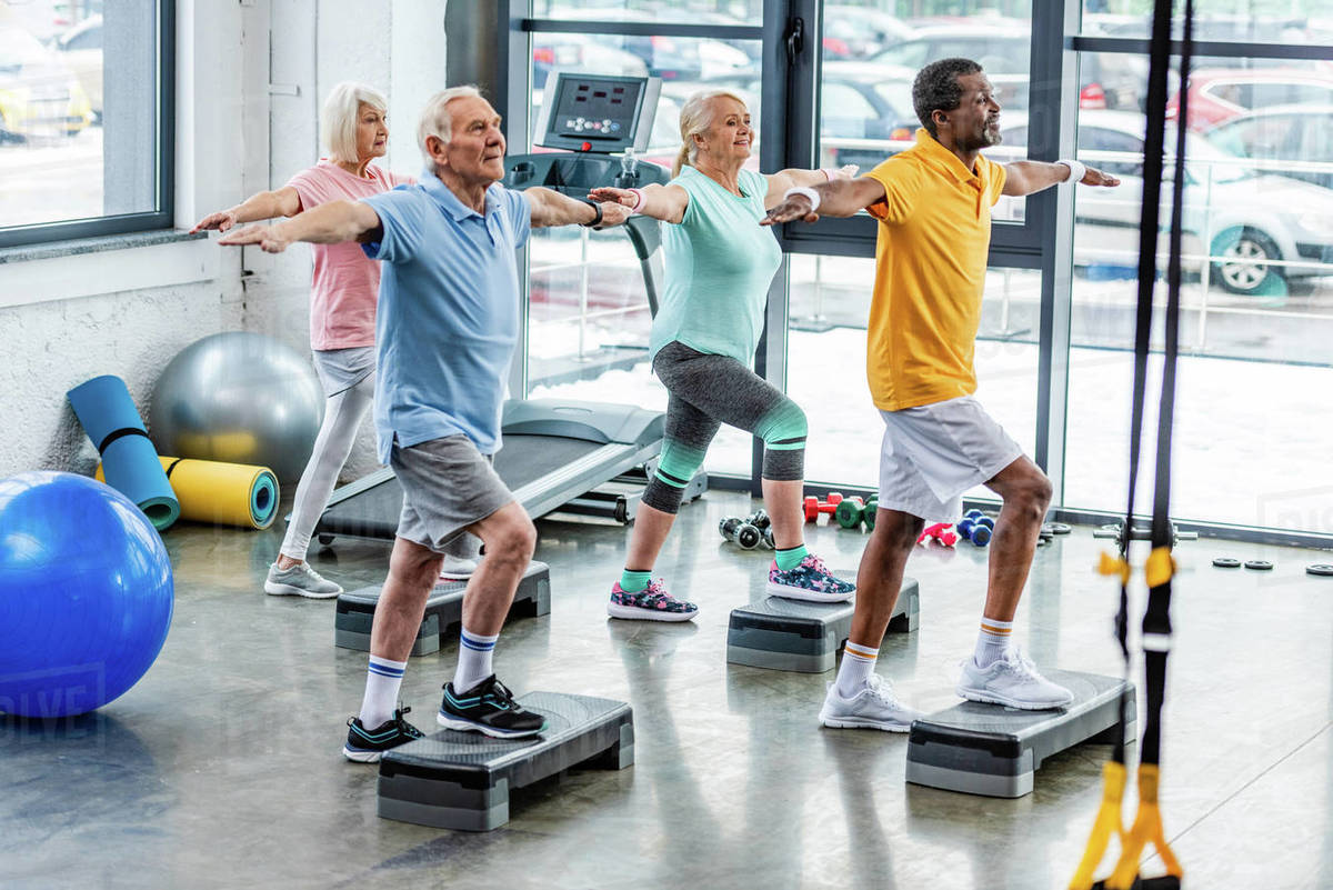Selective focus of senior multicultural athletes synchronous exercising ...
