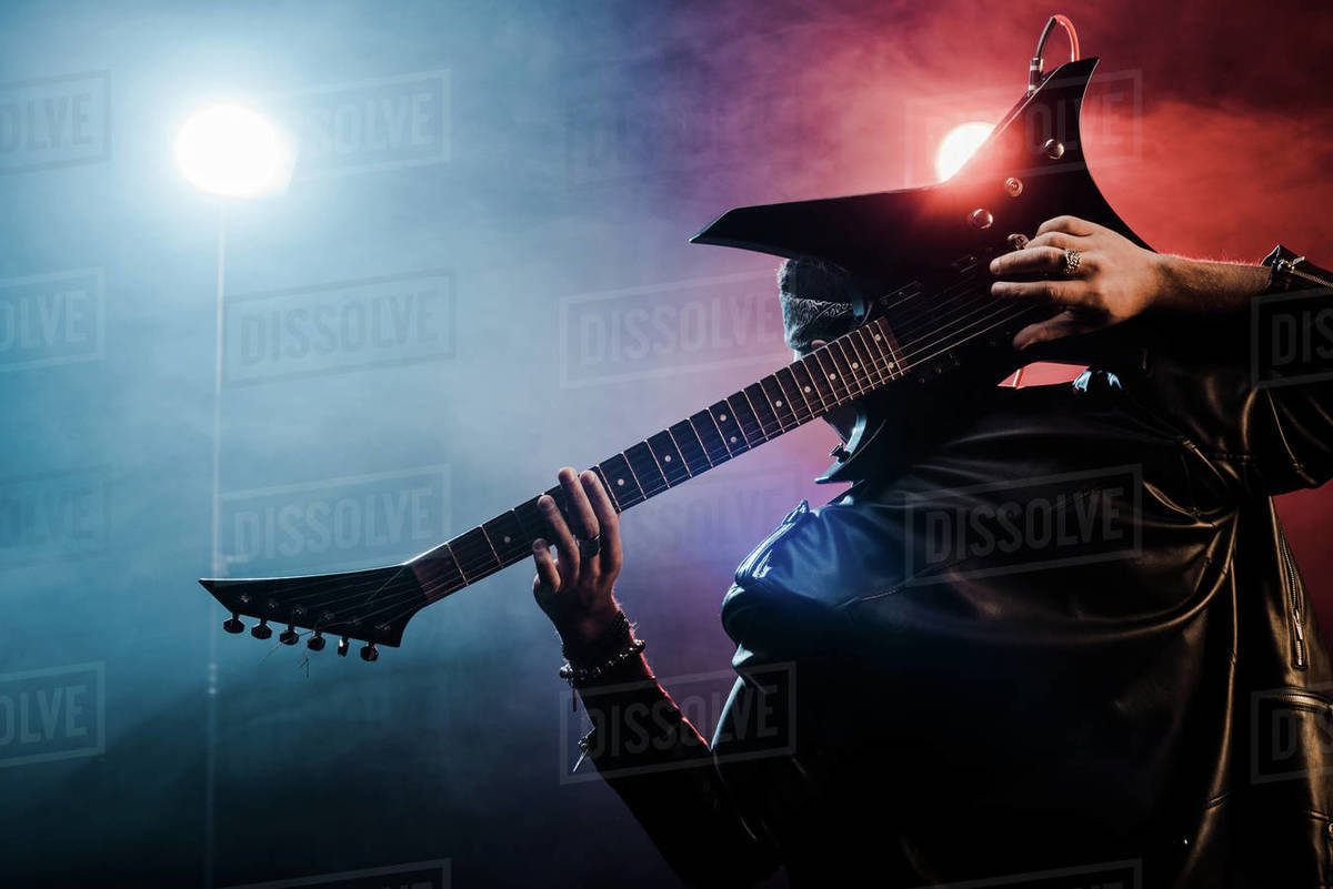 Back view of male musician in leather jacket playing on electric guitar ...