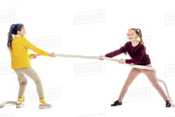 Two cheerful schoolgirls pulling rope isolated on white - Royalty-free ...