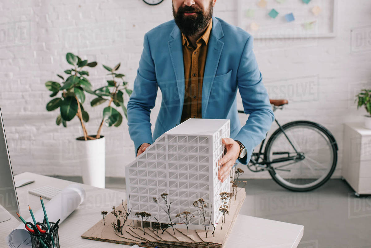Cropped view of adult male architect in formal wear working on house ...