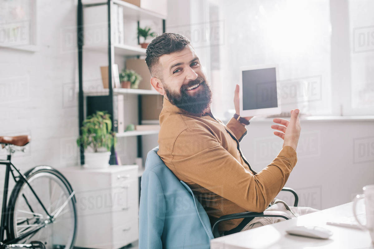 Handsome adult business man sitting at office desk and using digital ...