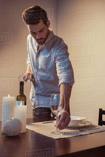 Handsome young man serving table for romantic dinner - Royalty-free ...