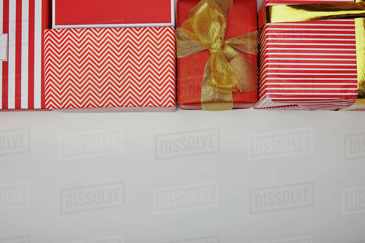 Top view of presents wrapped in colorful wrapping paper on grey ...