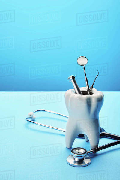 Close up view of white tooth model, stethoscope and stainless dental ...