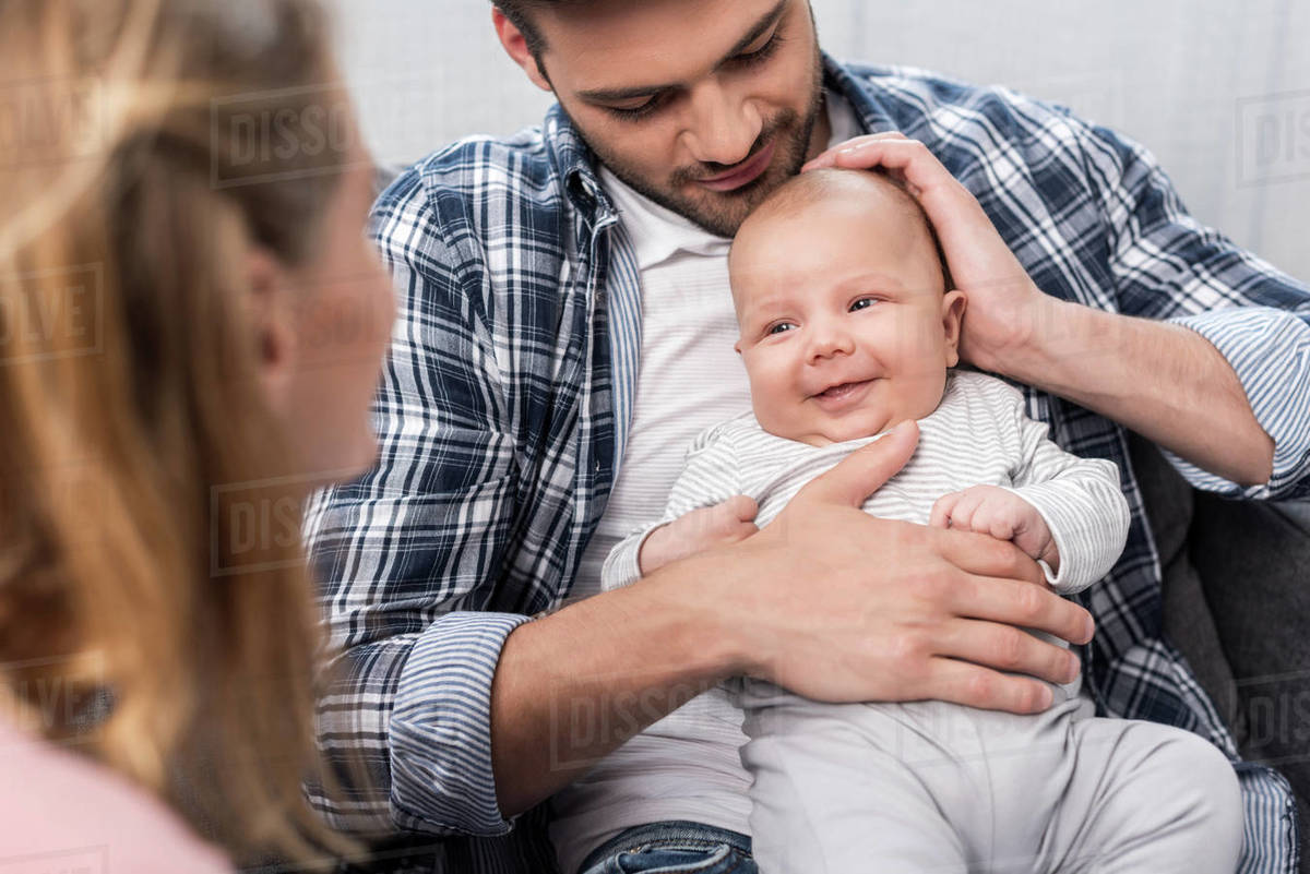 Happy parents holding their little smiling baby boy - Royalty-free ...