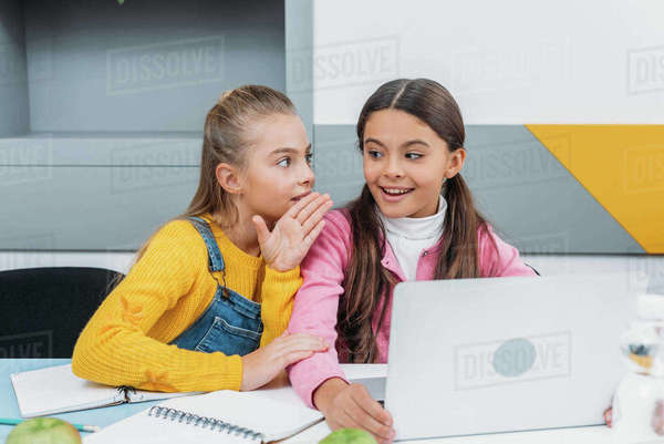 Happy classmates talking and using laptop during class - Royalty-free ...