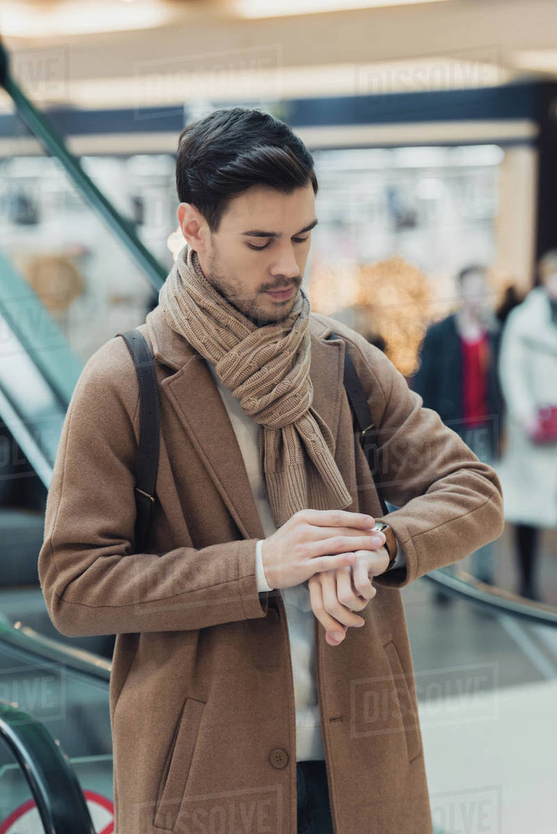 Handsome man looking at watch in shopping mall - Royalty-free Stock ...