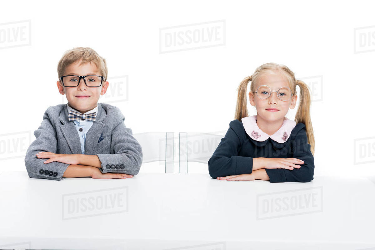Adorable pupils sitting at desk isolated on white - Royalty-free Stock ...