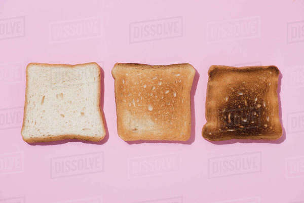 Top view of toasts in various roast stages on pink surface - Royalty ...