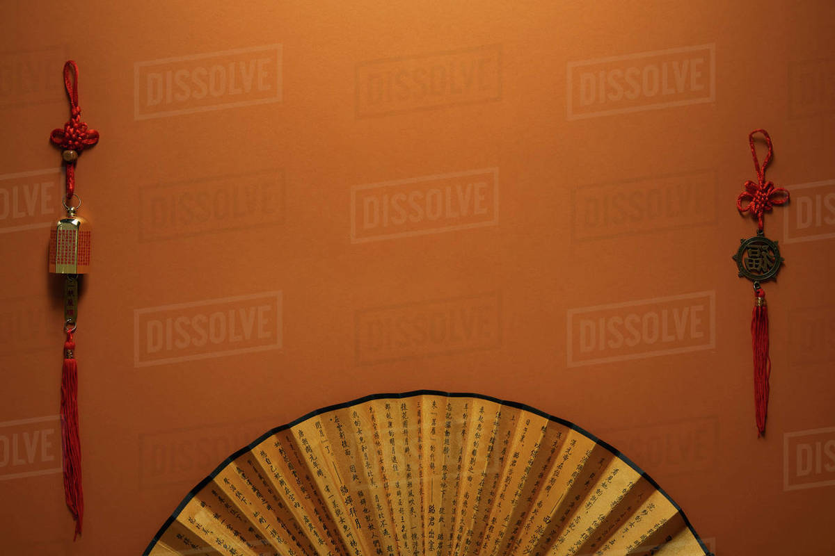 top view of golden fan with hieroglyphs and traditional chinese ...