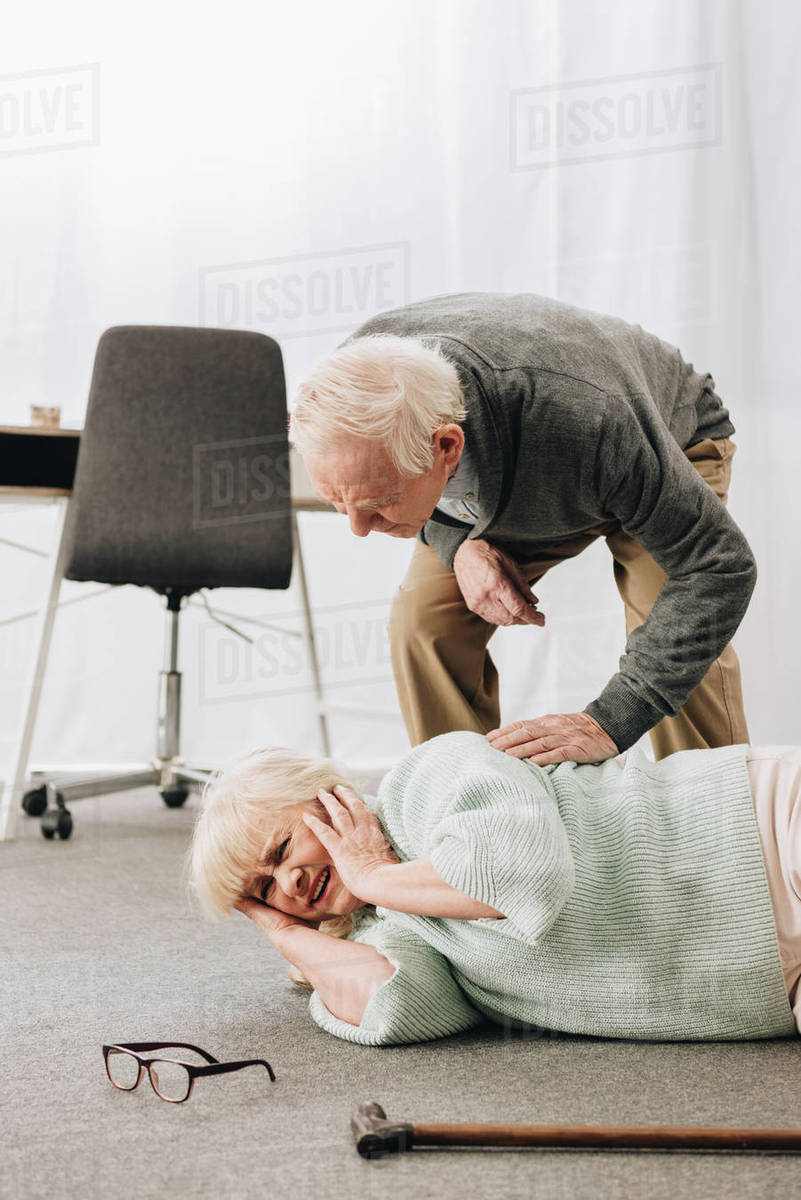 Old men helping wife who fell down on floor - Stock Photo - Dissolve