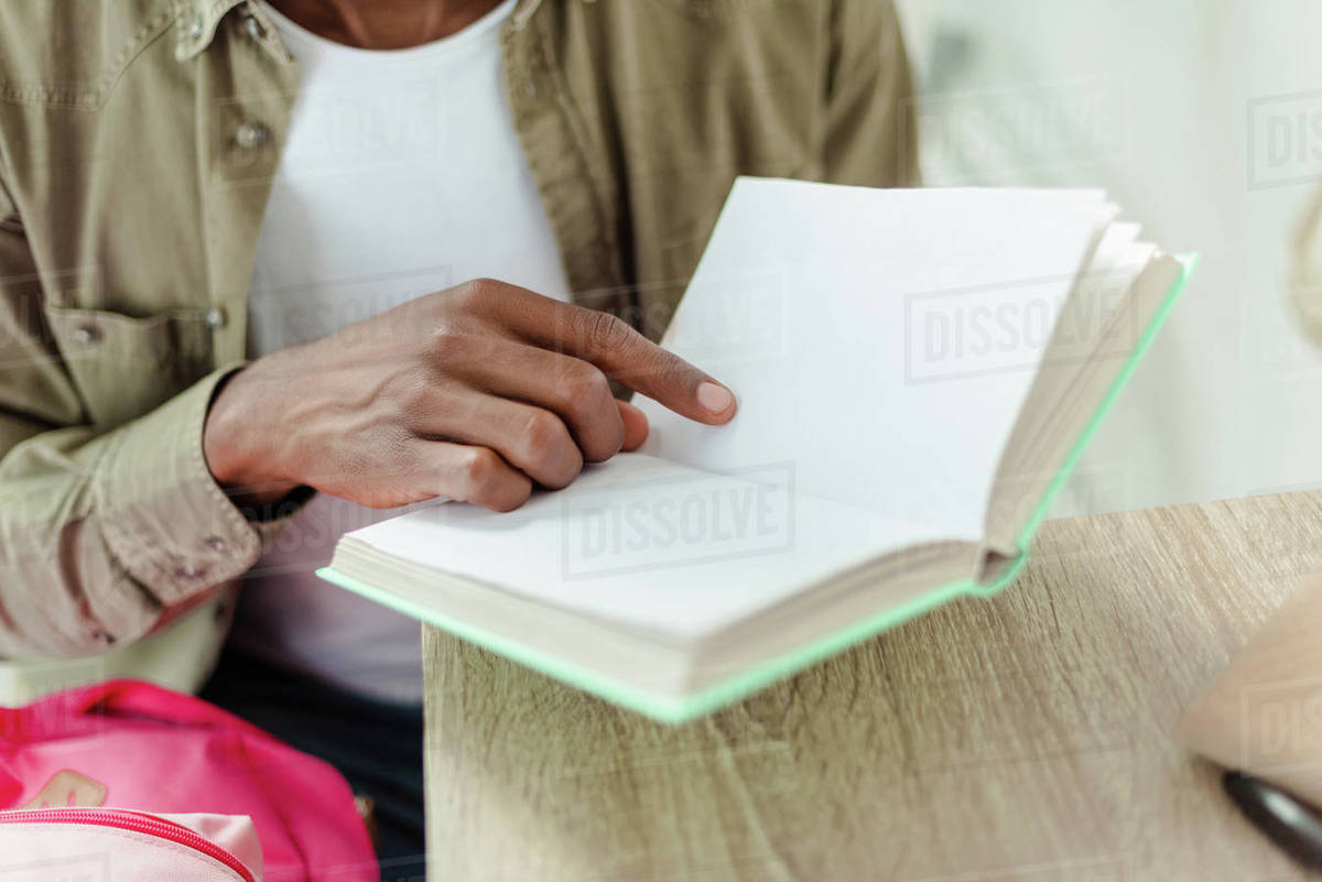 Cropped shot of a man pointing his finger at an open book page ...