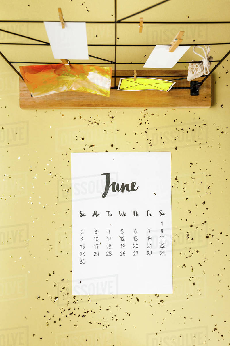 Top view of June calendar with golden confetti and cards with ...
