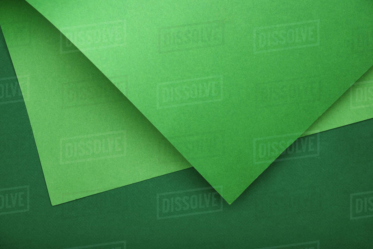 View from above of green paper on colored background - Stock Photo ...
