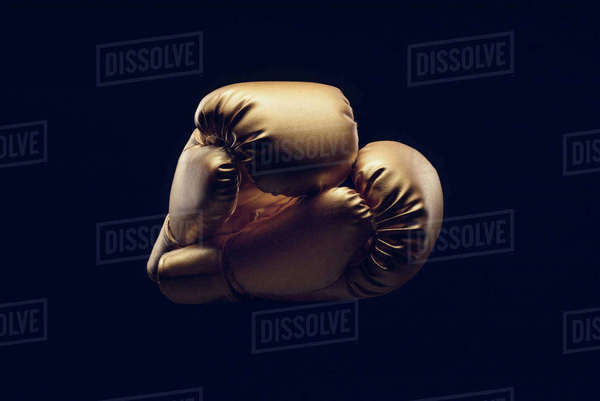 Close up view of pair of golden boxing gloves isolated on black ...