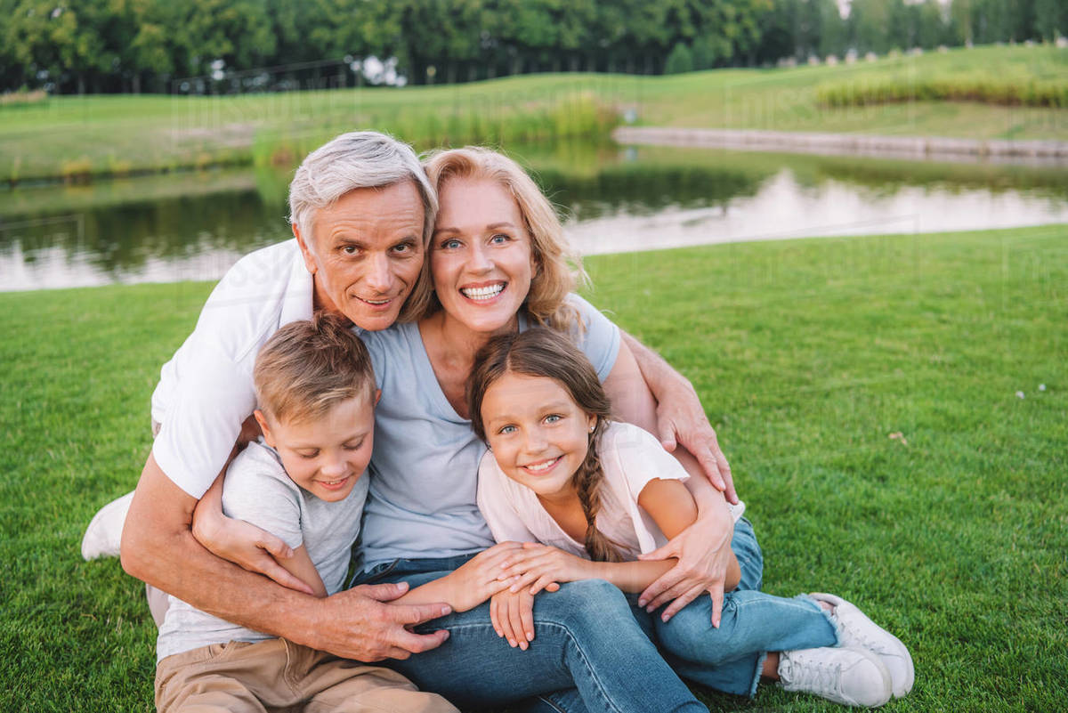 cheerful grandparents and little grandchildren resting together on ...