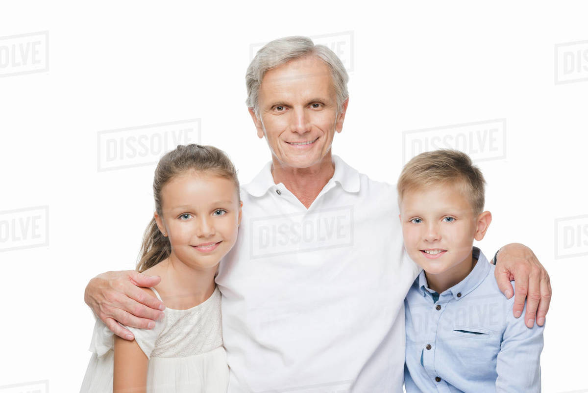 happy grandfather with grandchildren embracing and smiling at camera ...