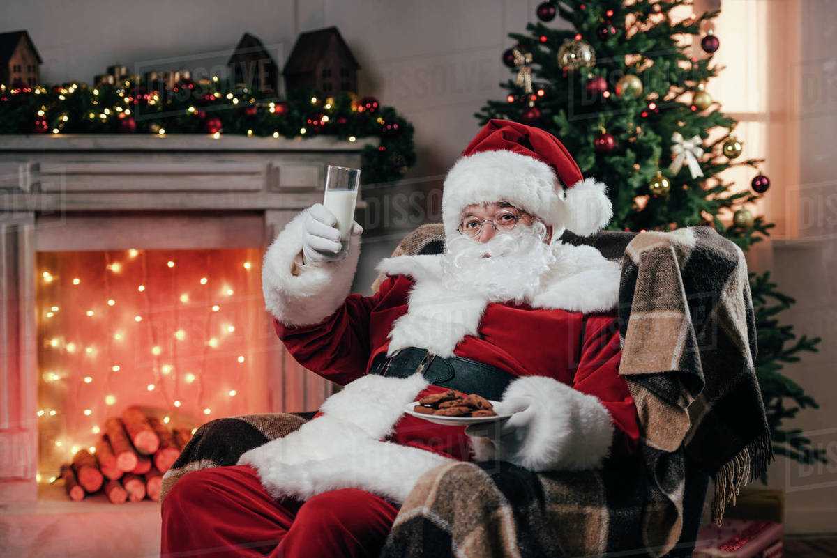 santa claus eating traditional cookies and milk - Stock Photo - Dissolve