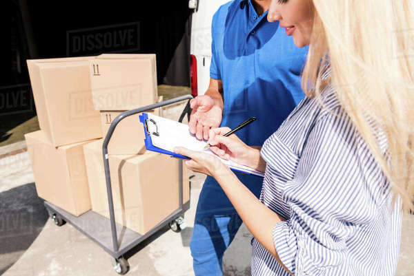 Cropped shot of courier giving delivery document to young woman - Stock ...