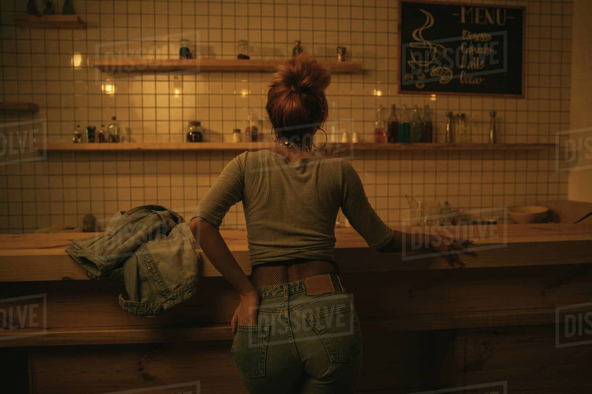 Rear view of elegant fashionable girl posing at bar counter - Royalty ...