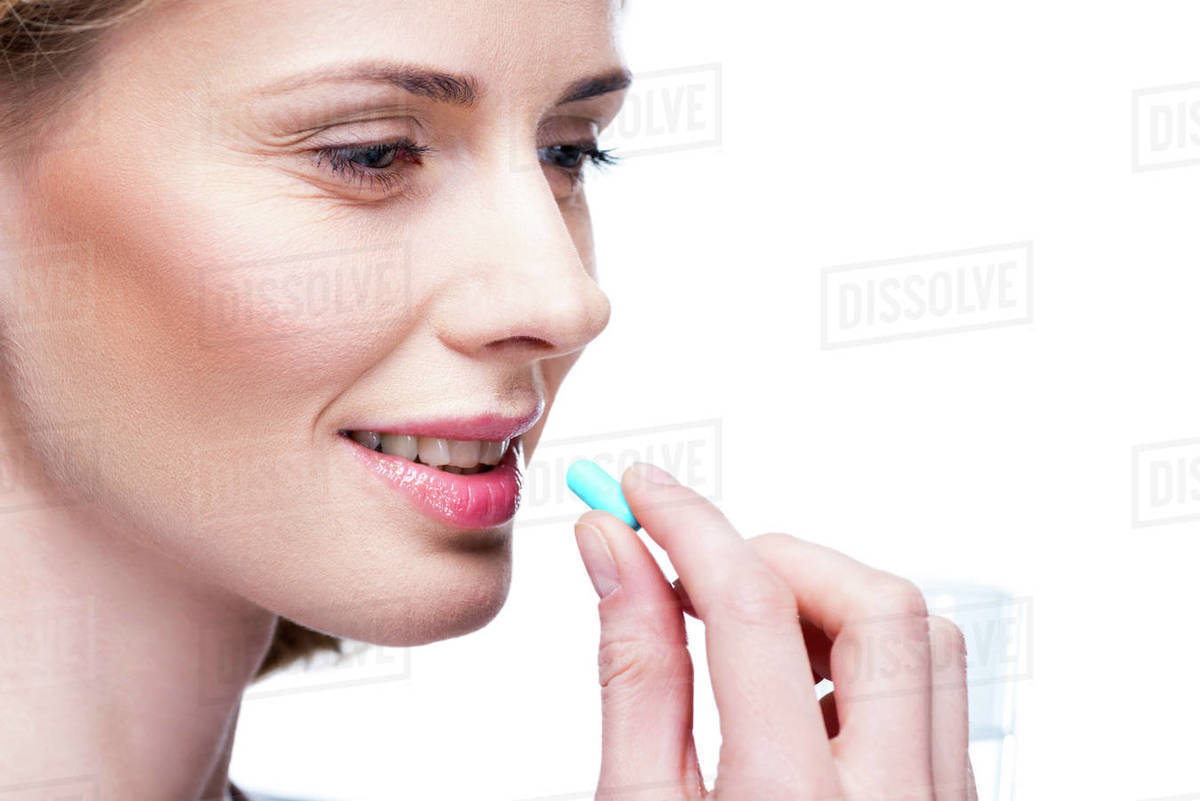 Attractive smiling woman with pill, isolated on white - Royalty-free ...