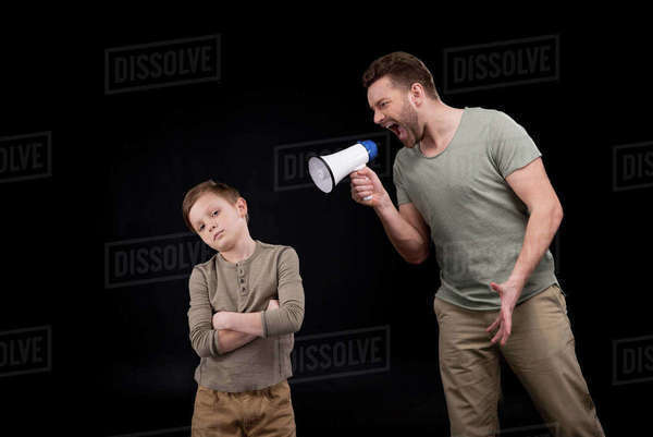 Father with megaphone screaming at little son standing with crossed ...