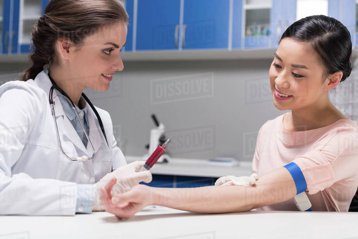 Young doctor taking blood sample from patient at laboratory - Stock ...