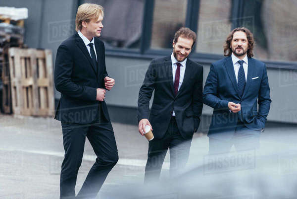Confident professional middle aged businessmen walking together on ...
