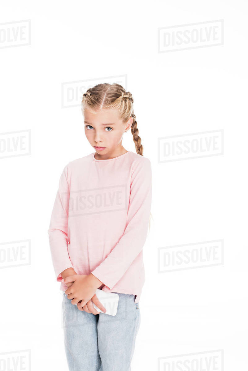 Young child holding smartphone with guilty look on her face, isolated on white - Stock Photo ...