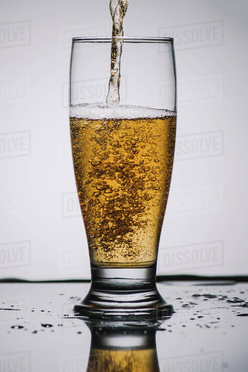 Pouring light beer into transparent glass - Royalty-free Stock Photo ...